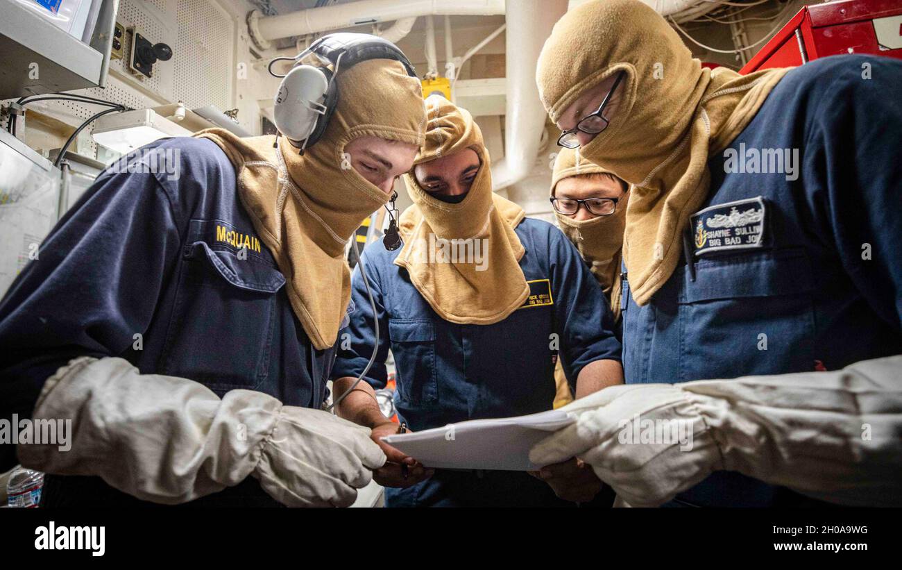 Sailors review a repair locker watch bill in a repair locker during a ...