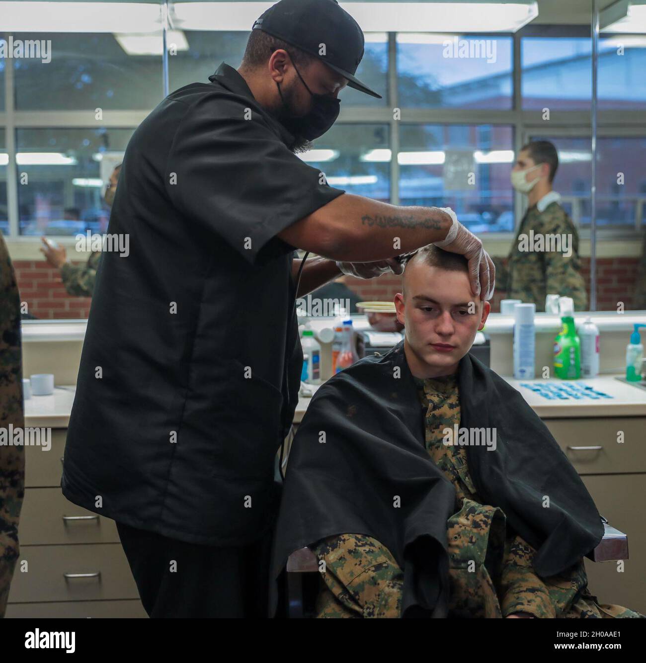 Ernest Watson, a recruit barber, cuts a recruit’s hair in the receiving ...