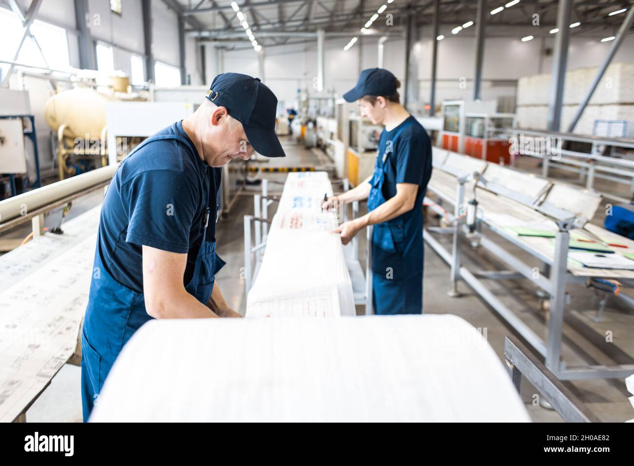 Workers in a factory carry out technological processes on a conveyor ...