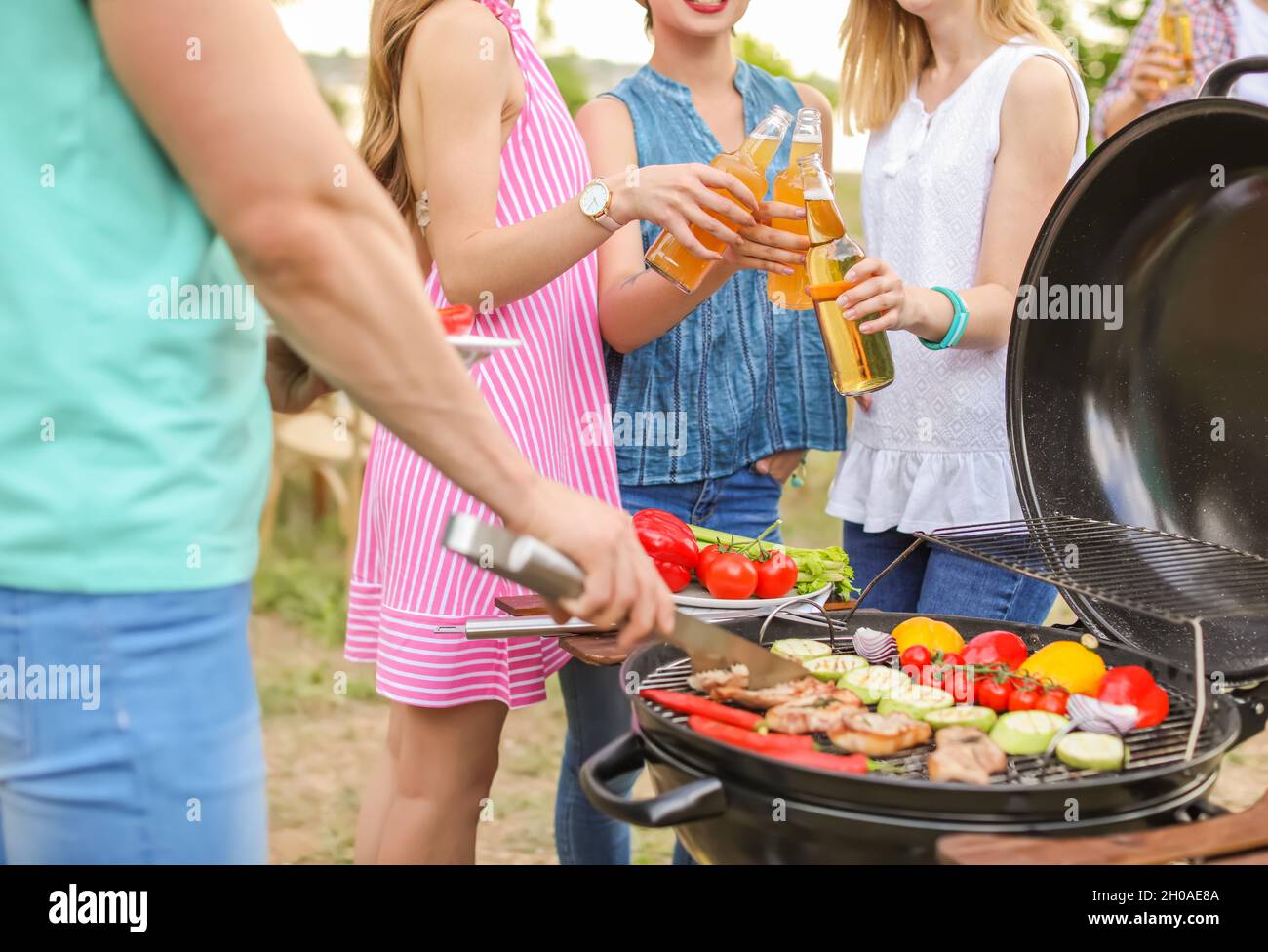 Young people having barbecue with modern grill outdoors Stock Photo - Alamy