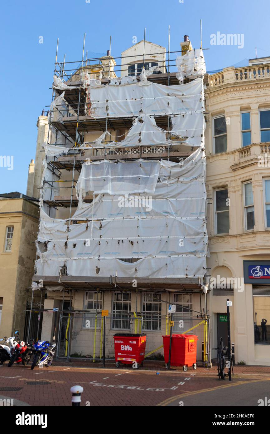 Scaffolding on a building with poorly maintained tarpaulin, uk Stock ...