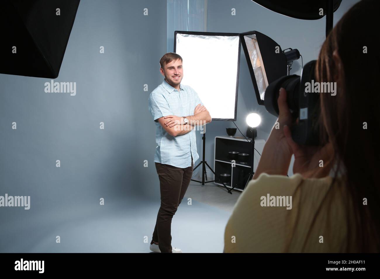 Handsome model posing for professional photographer in photo studio ...