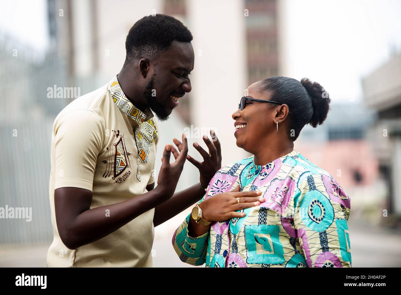 beautiful african couple talking on the street together gesturing hands ...