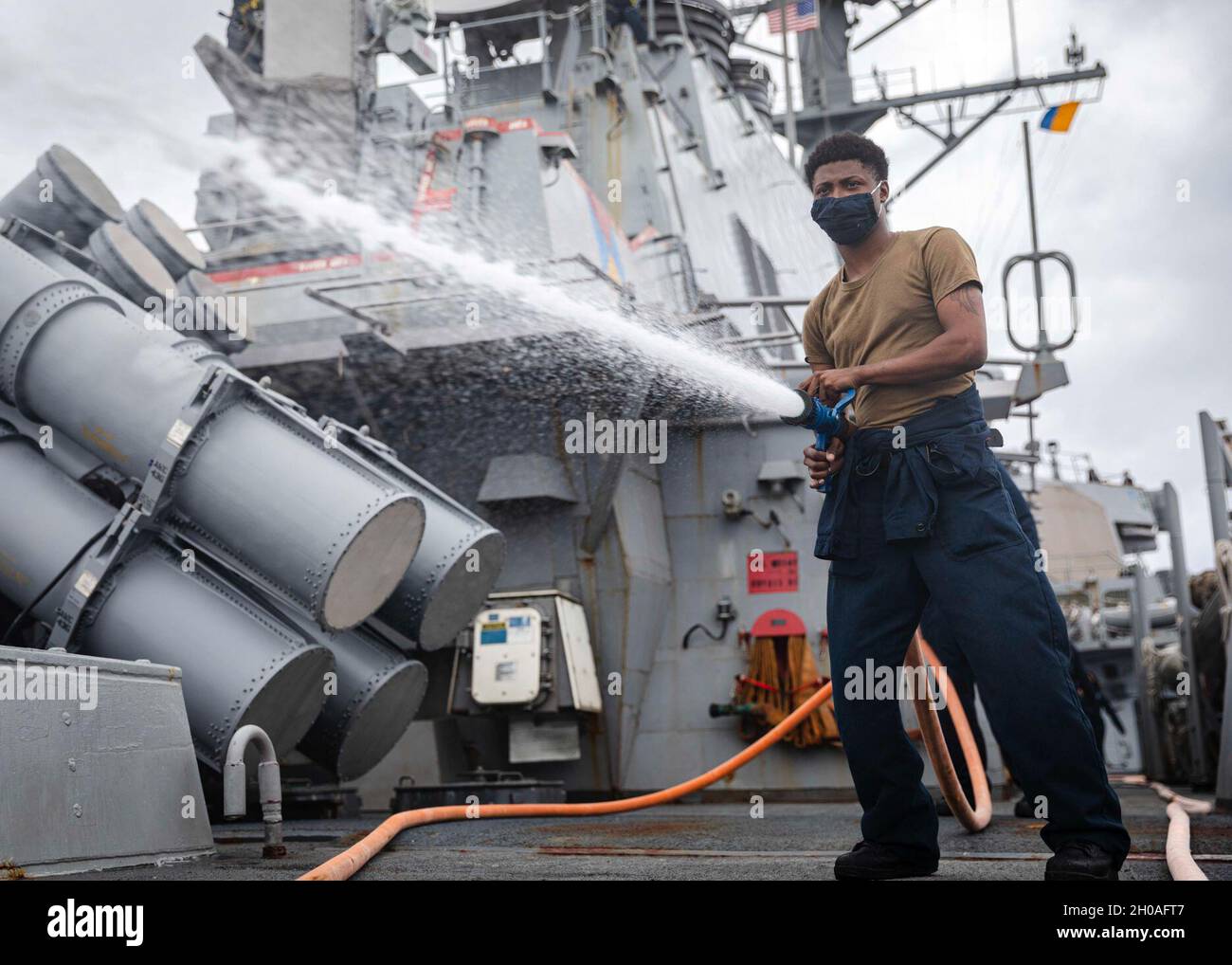 Machinist Mate 3rd Class Jonathan Pipes, from St Louis, Mo., sprays ...