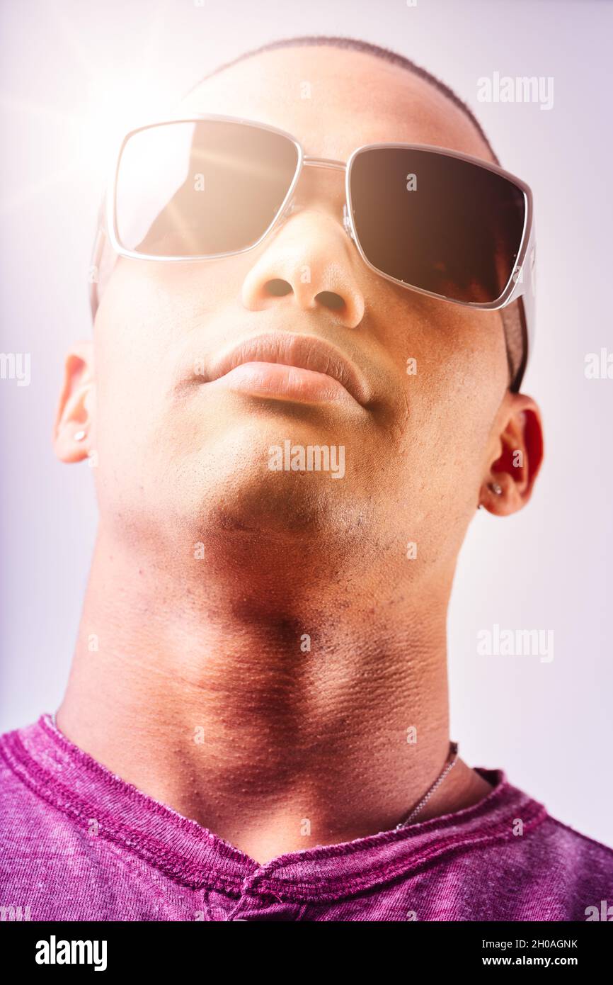 Trendy Black man in modern shades or sunglasses posing with head tilted ...