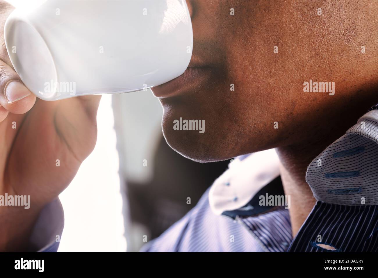 Cropped high ket close up of a young black man drinking coffee from a ...