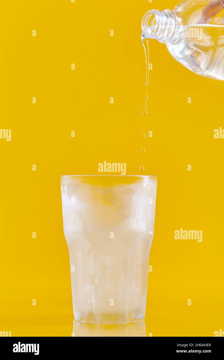 Cold water pouring from a bottle into a glass Stock Photo - Alamy