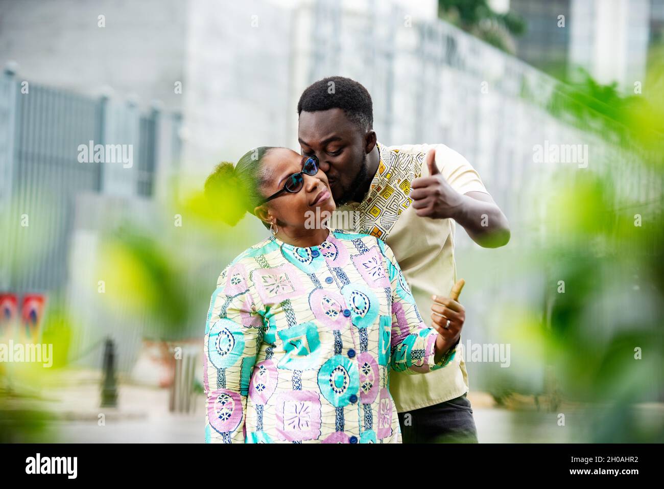 happy beautiful mature couple, young man kissing his wife on the street ...