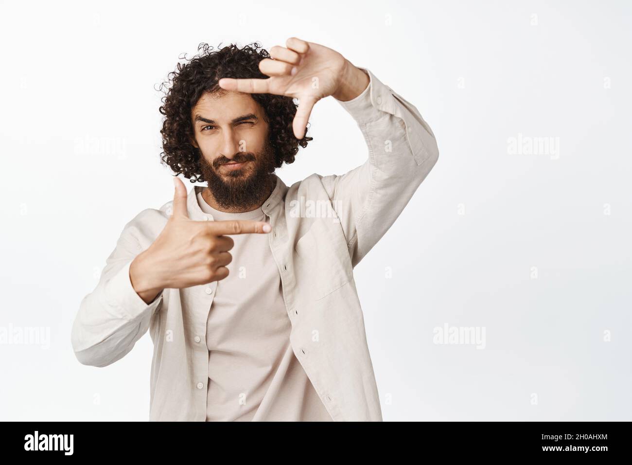 Handsome creative man looking through hand frames, searching perfect ...