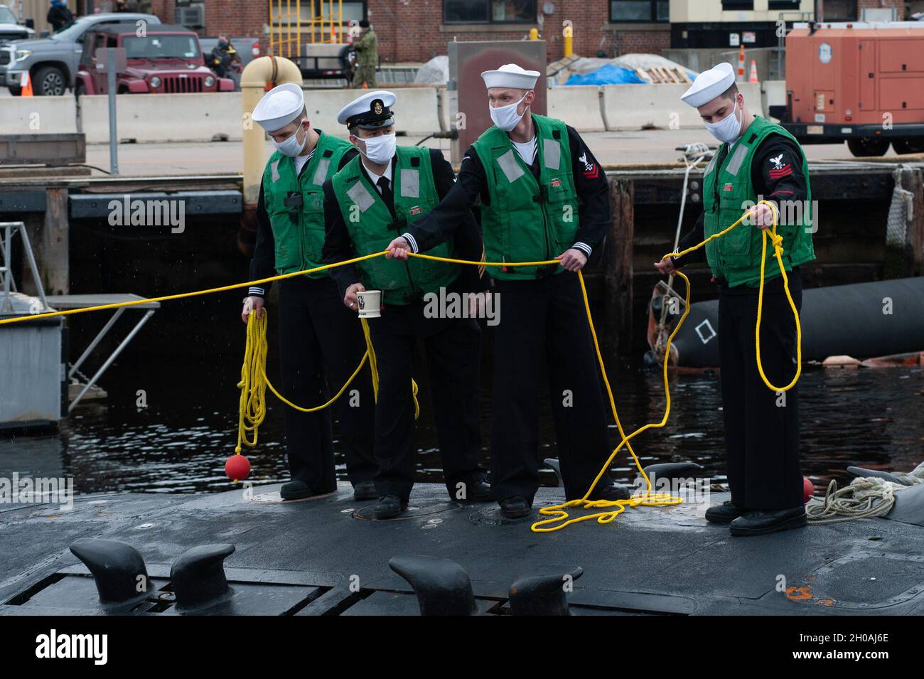 Line handlers on USS North Dakota (SSN 784) moor the boat to the pier ...