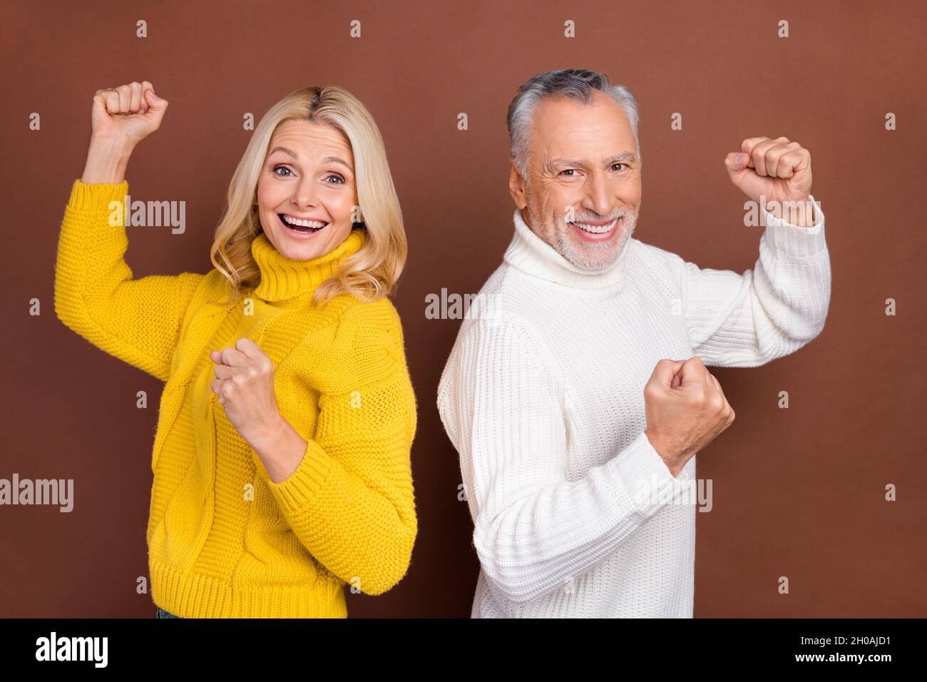 Portrait of two attractive cheerful lucky grey-haired people rejoicing ...