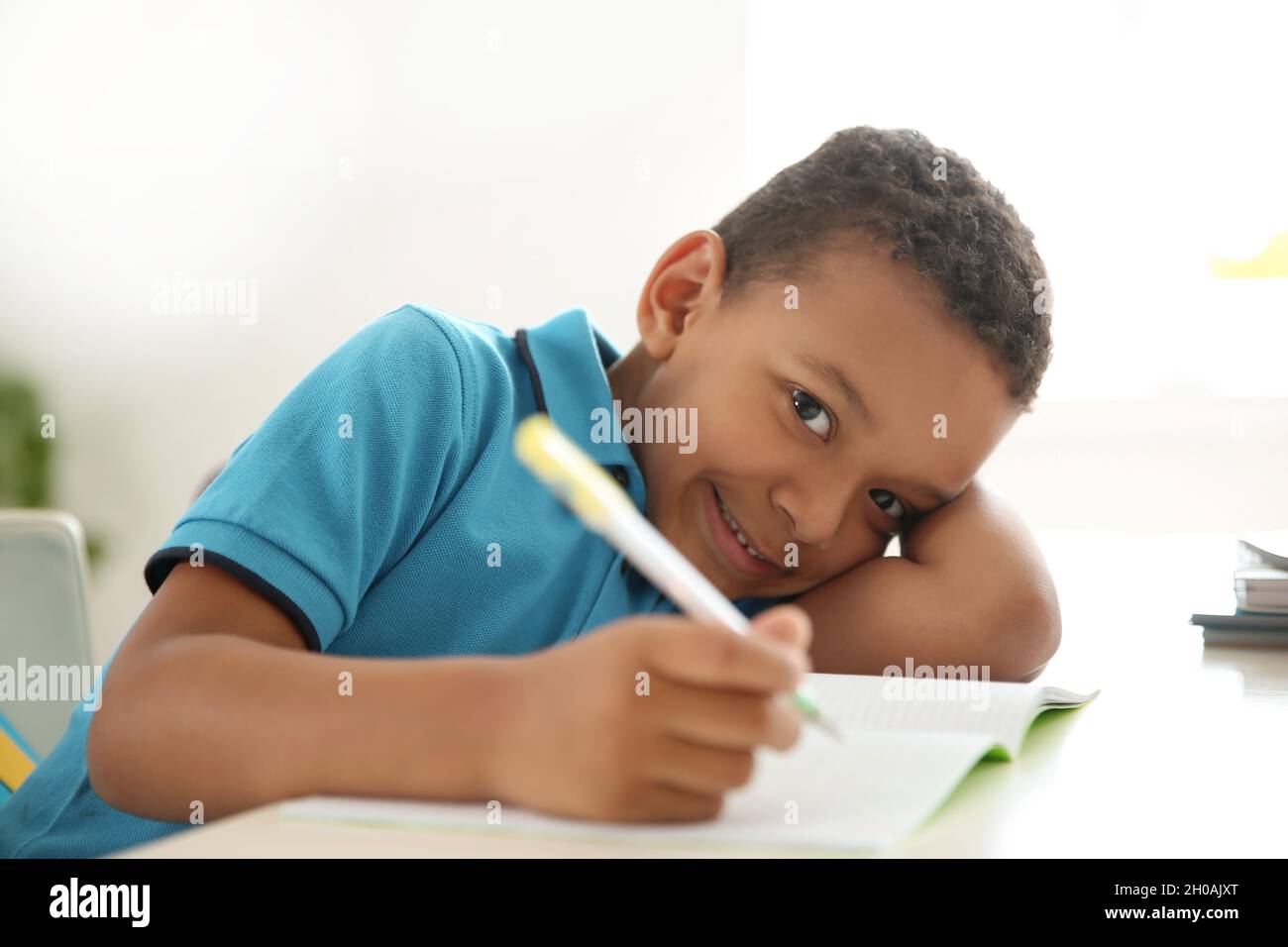 Cute little child doing assignment at desk in classroom. Elementary ...