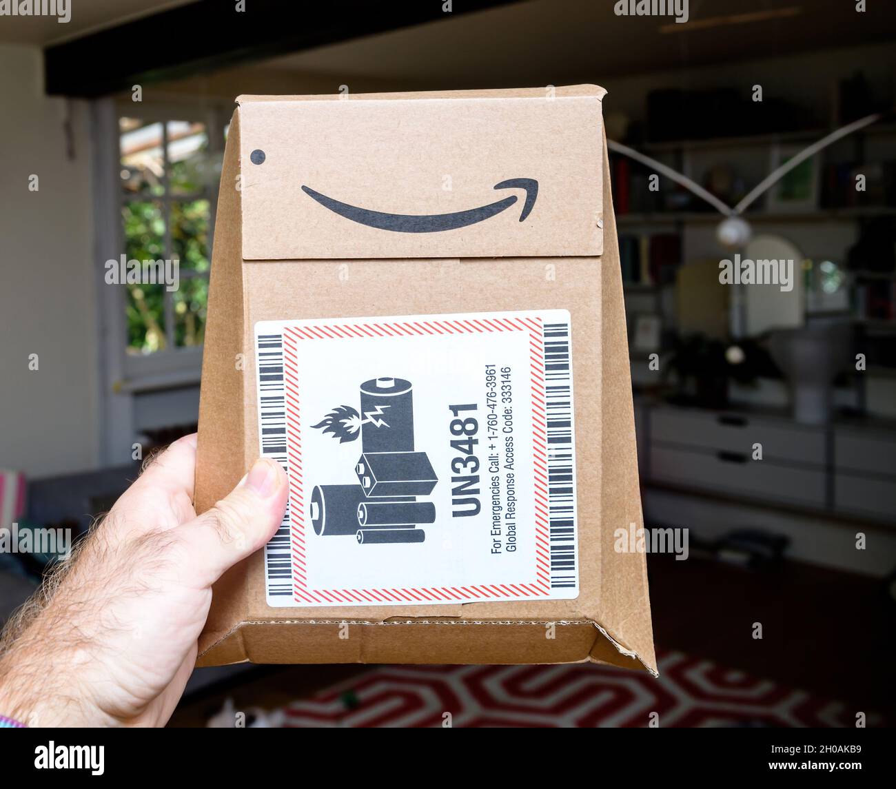 holding package of Amazon Prime cardboard package with UN3481 sticker ...