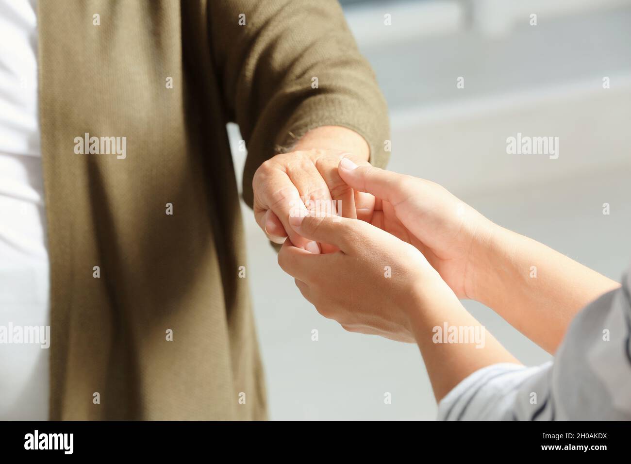 Helping hands on gray background, closeup. Elderly care concept Stock ...