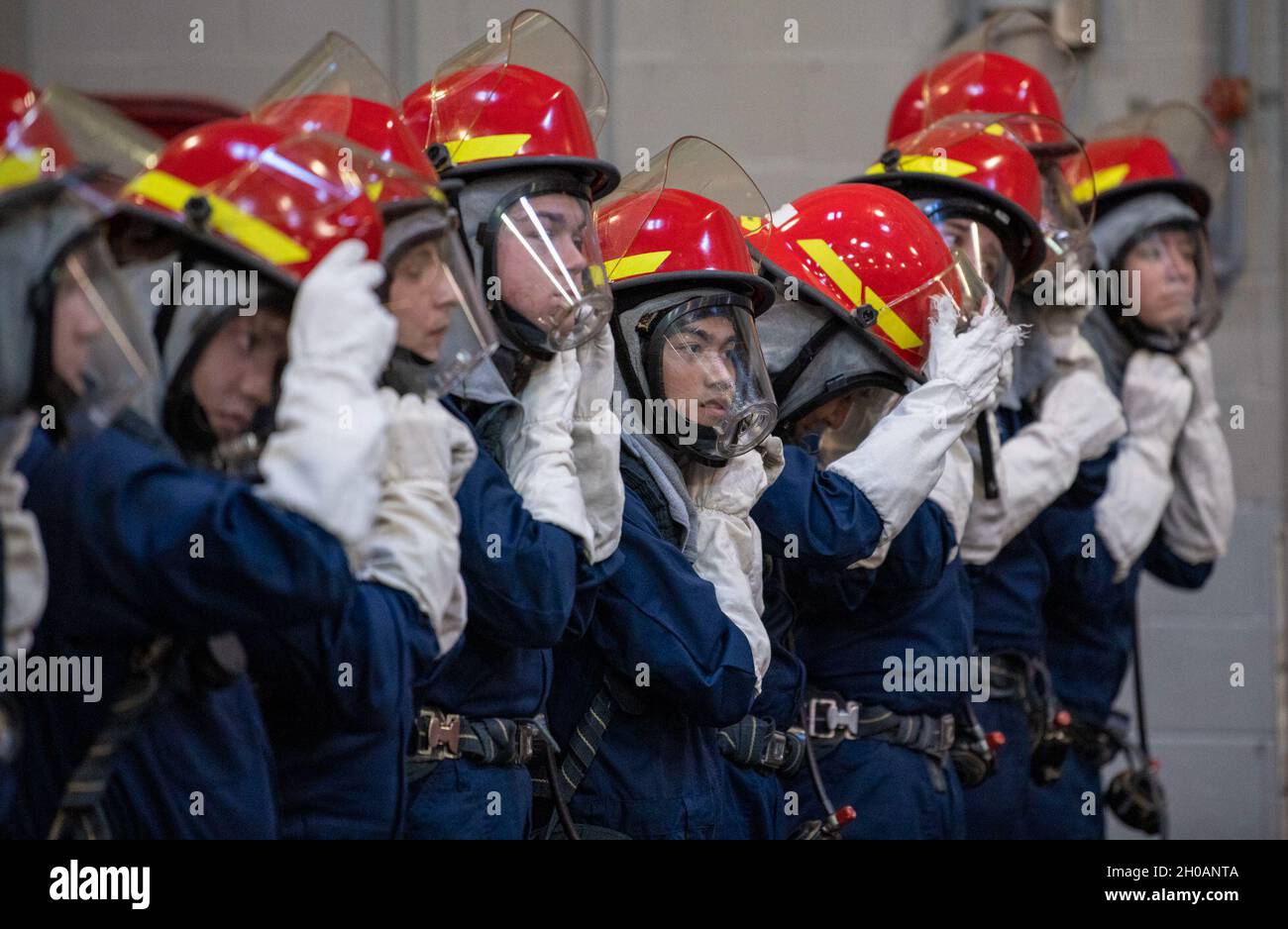Recruits secure their head gear during firefighting training inside the ...