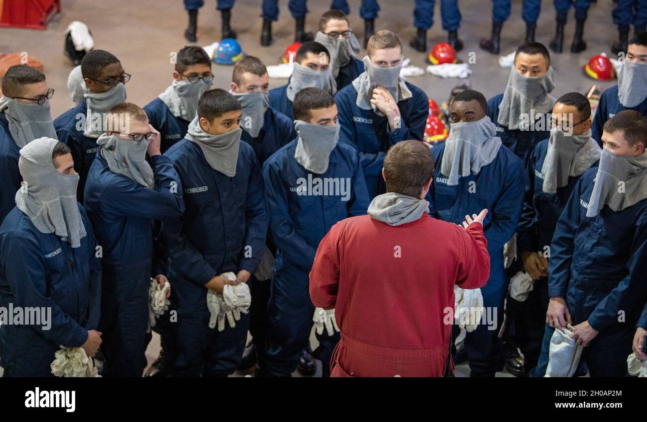 Recruits listen to an instructor during firefighting training inside ...