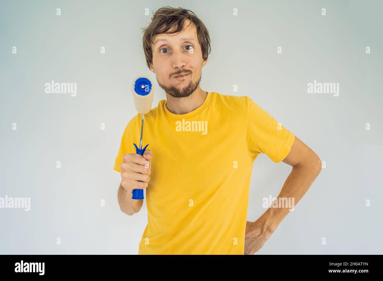 One male house painter worker painting and priming wall with painting ...