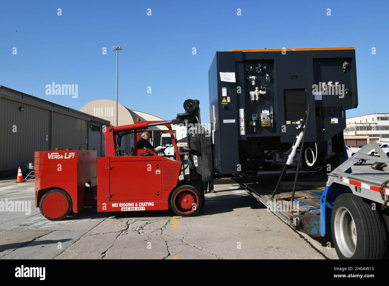 A contract forklift operator lifts a 5-axis computerized numerical ...