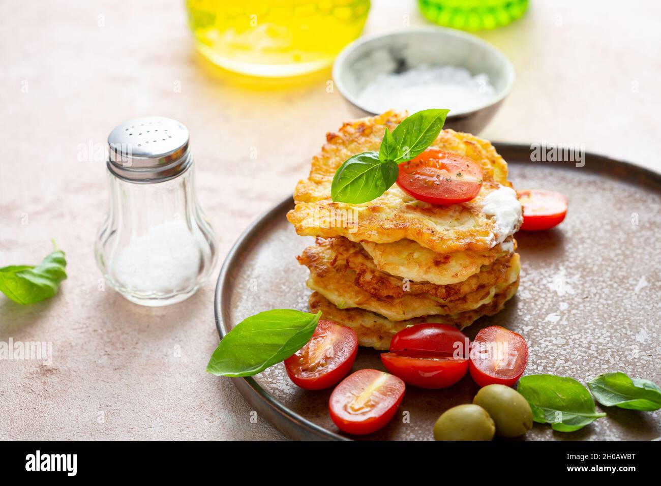 Stack of potatoes fritters served with cherry tomato and olive Stock ...