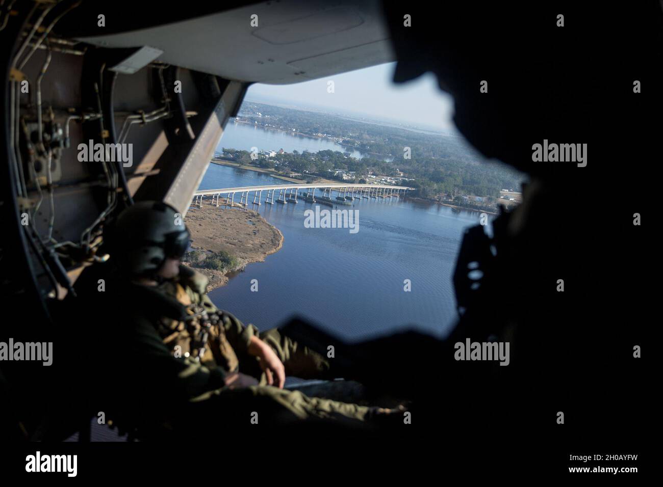 A U.S. Marine Corps crew chief looks out he rear of an MV-22 Osprey ...