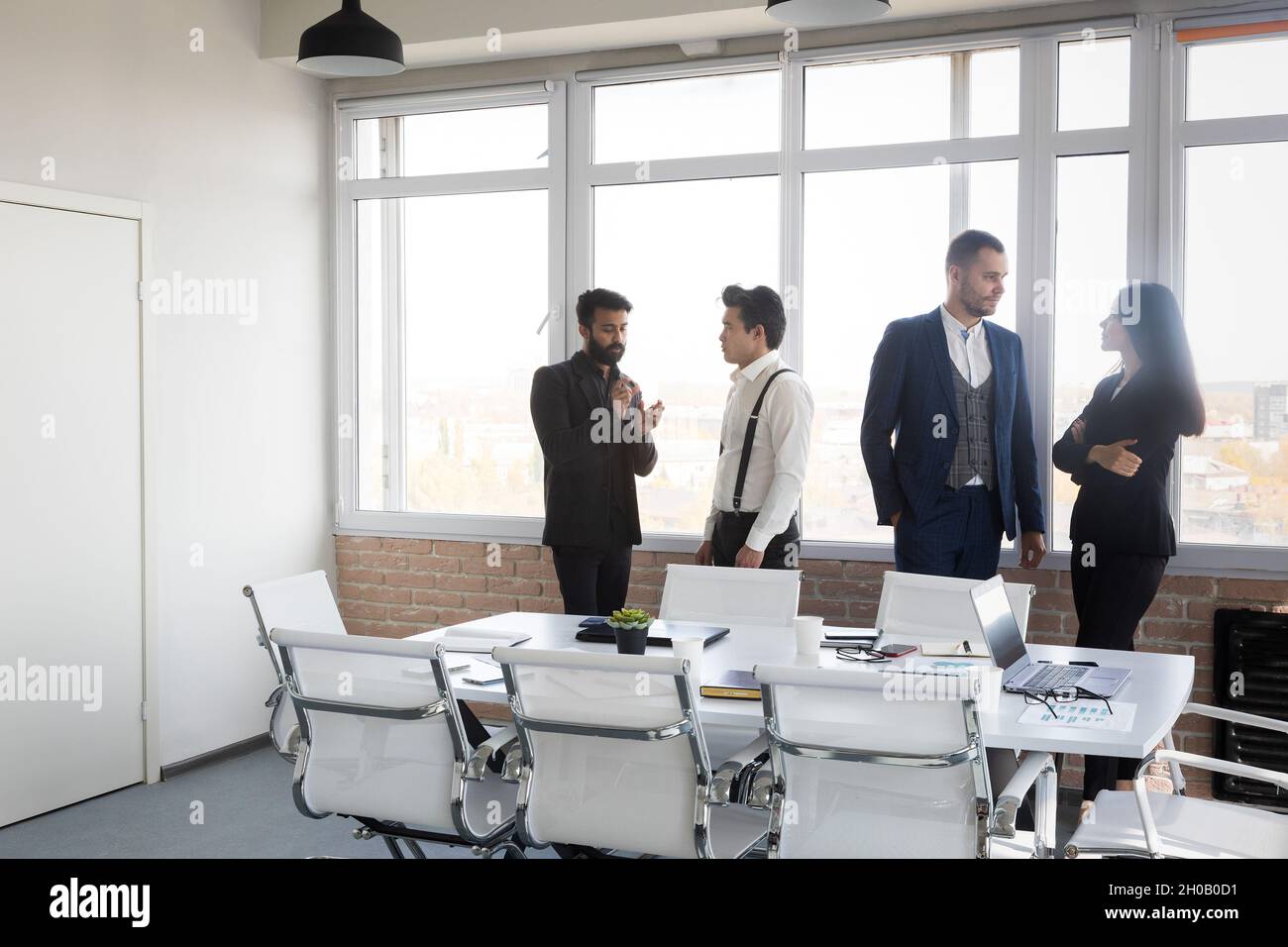 Silhouettes of people against the window. A team of young businessmen ...