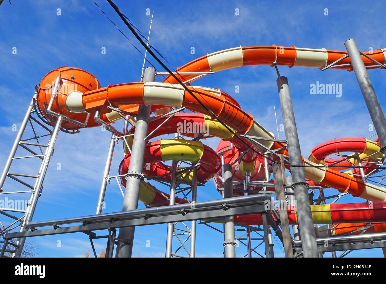 Bright colored water slides in the water park against the blue sky ...