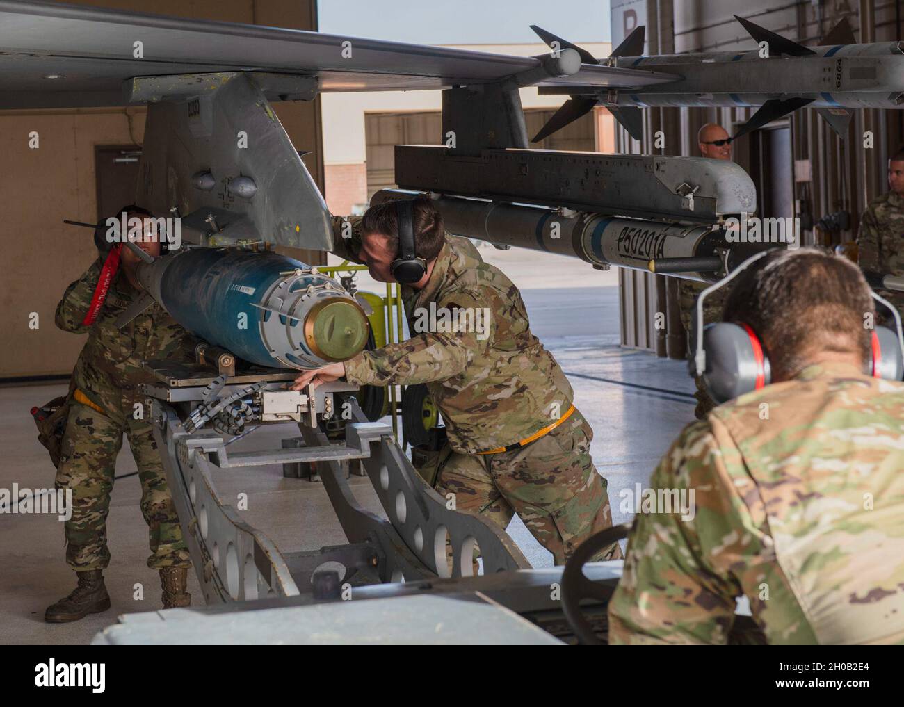 Airmen from the 849th Aircraft Maintenance Squadron, load an inert bomb ...