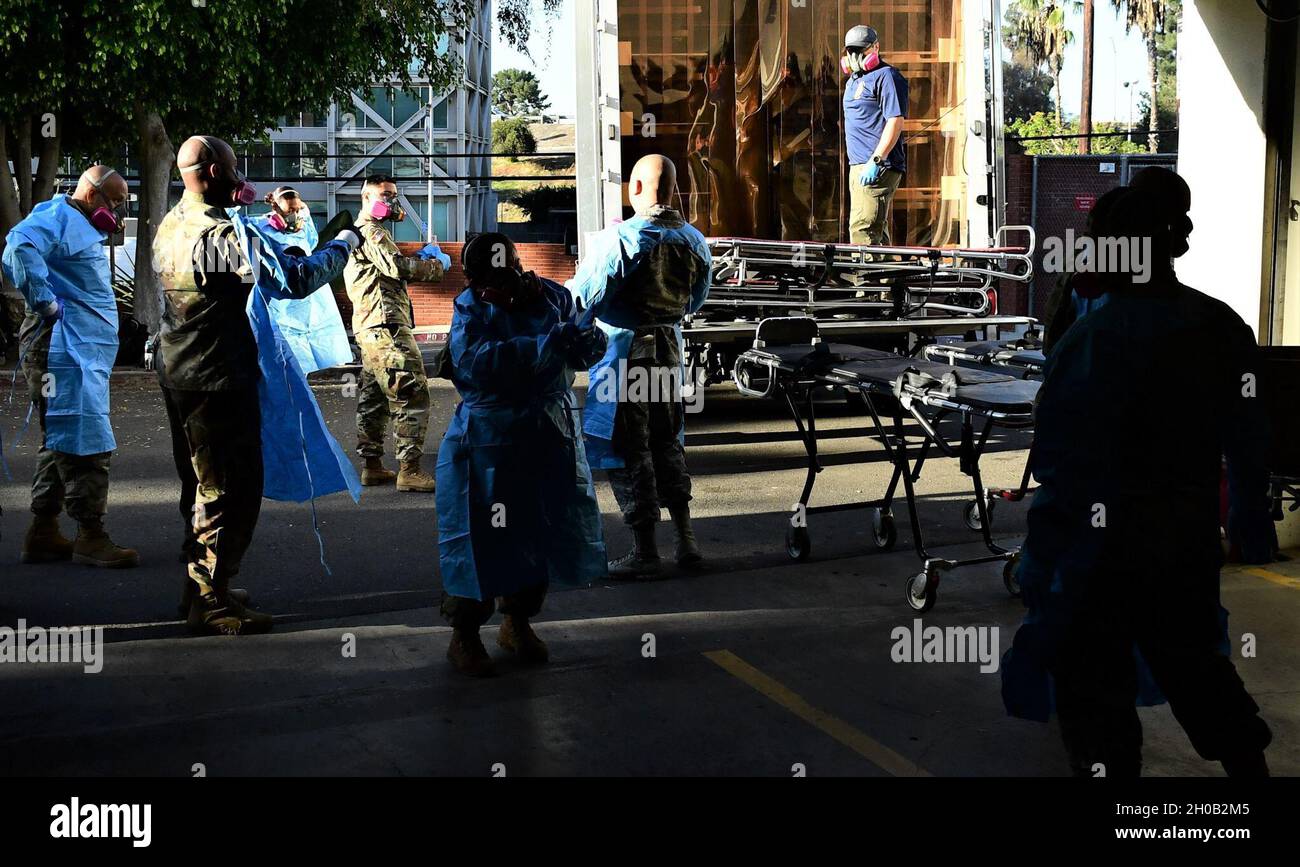 California National Guardsmen dawn disposable gowns, gloves, and face ...