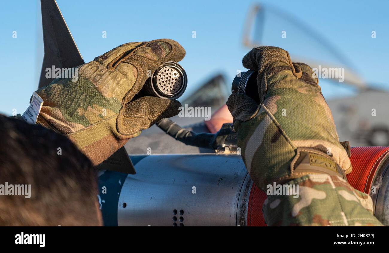 A weapons load crew member from the 57th Maintenance Squadron connects ...