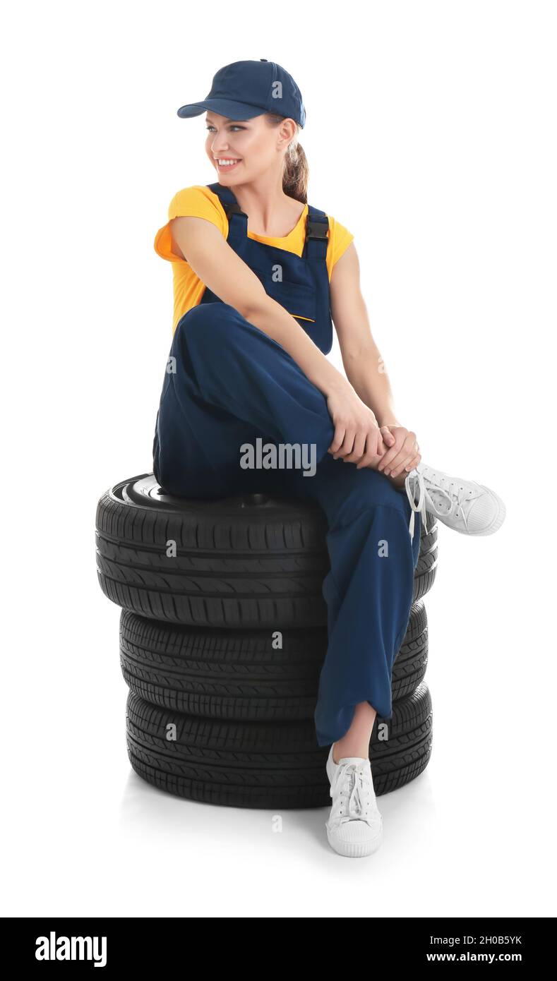 Female mechanic with car tires on white background Stock Photo - Alamy