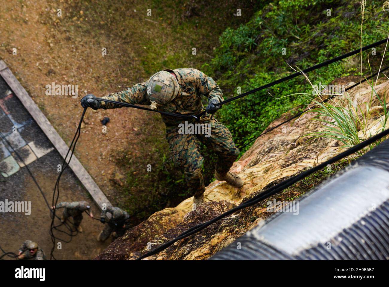 A U.S. Marine with 3d Marine Division rappels down a cliff during the ...