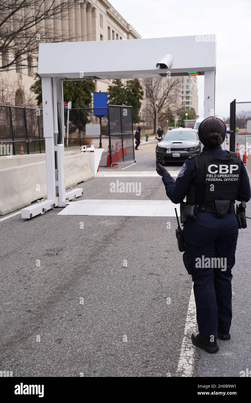 A U.S. Customs and Border Protection officer directs traffic into a ...