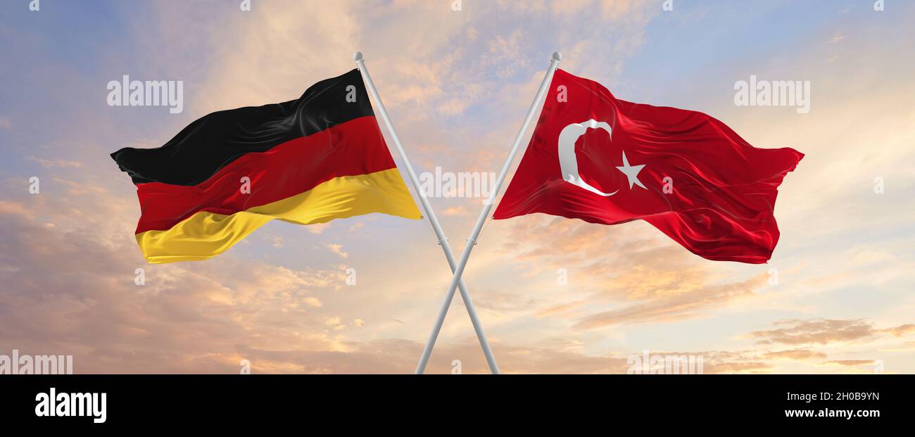 flags of Germany and Turkey waving in the wind on flagpoles against sky ...