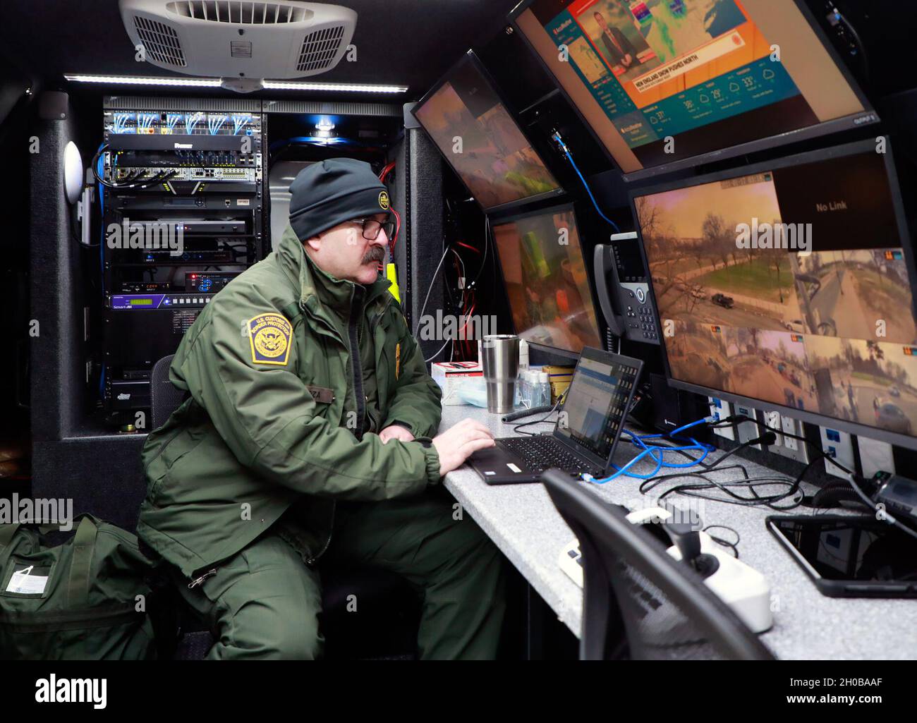 A U.S. Border Patrol Agent works inside a tactical communications truck ...