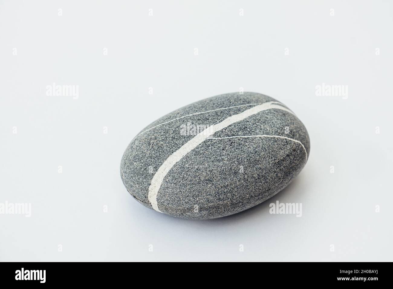 One sea stone of a round form on the light background. Top view of a ...