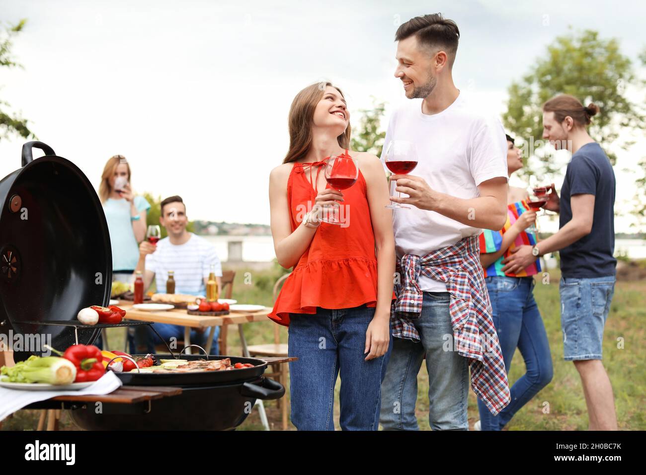 Young people having barbecue with modern grill outdoors Stock Photo - Alamy