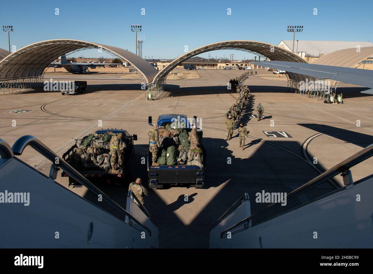 Oklahoma Army and Air National Guardsmen walk from a hangar to board a ...