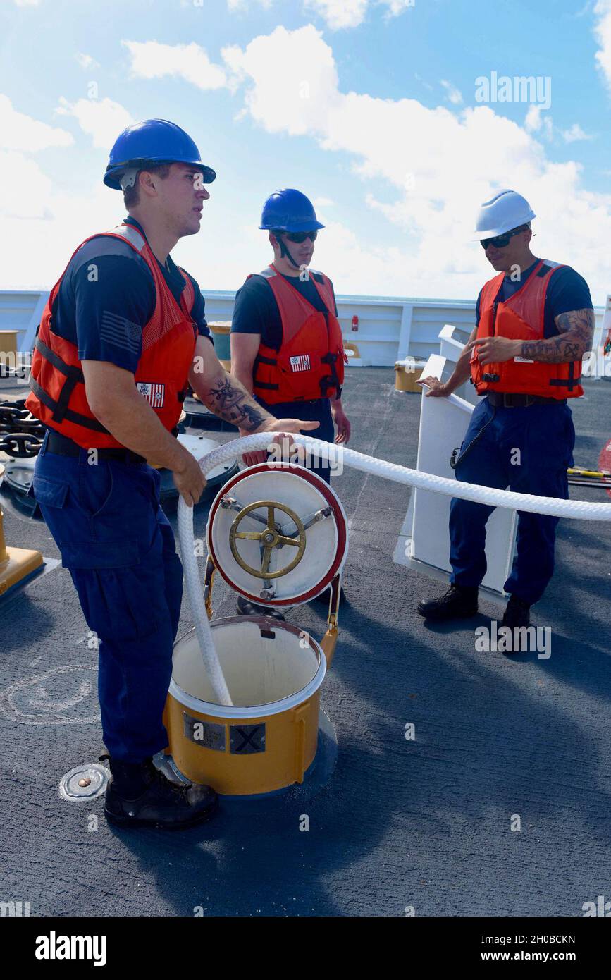 U.S. Coast Guard Petty Officer 3rd Class Miles Hess stows mooring line ...