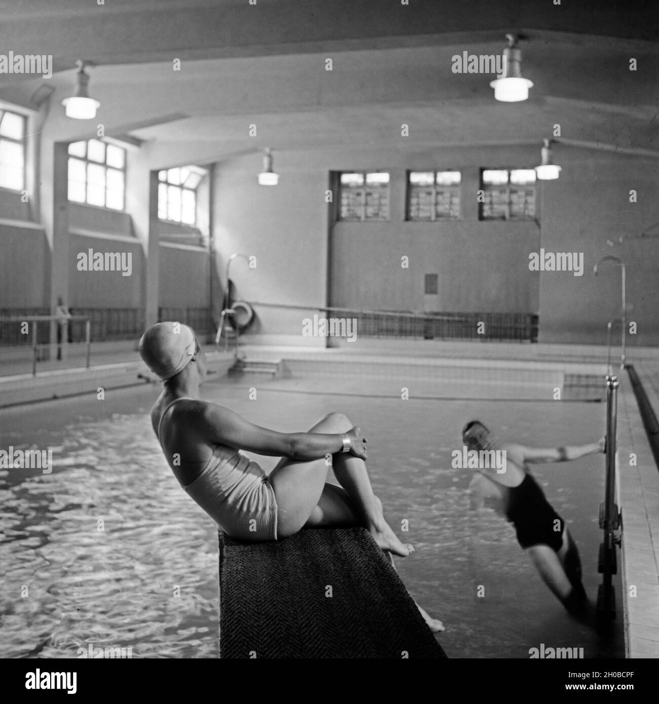Eine junge Frau und ein junger Mann in einem Hallenbad, Deutschland ...