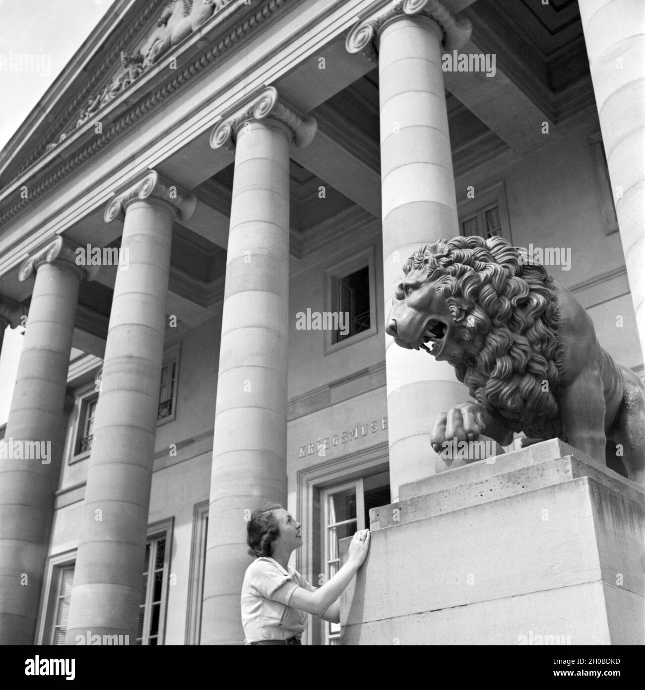 Eine Frau vor der Löwenstatue am Eingang von Schloss Rosenstein in Bad ...