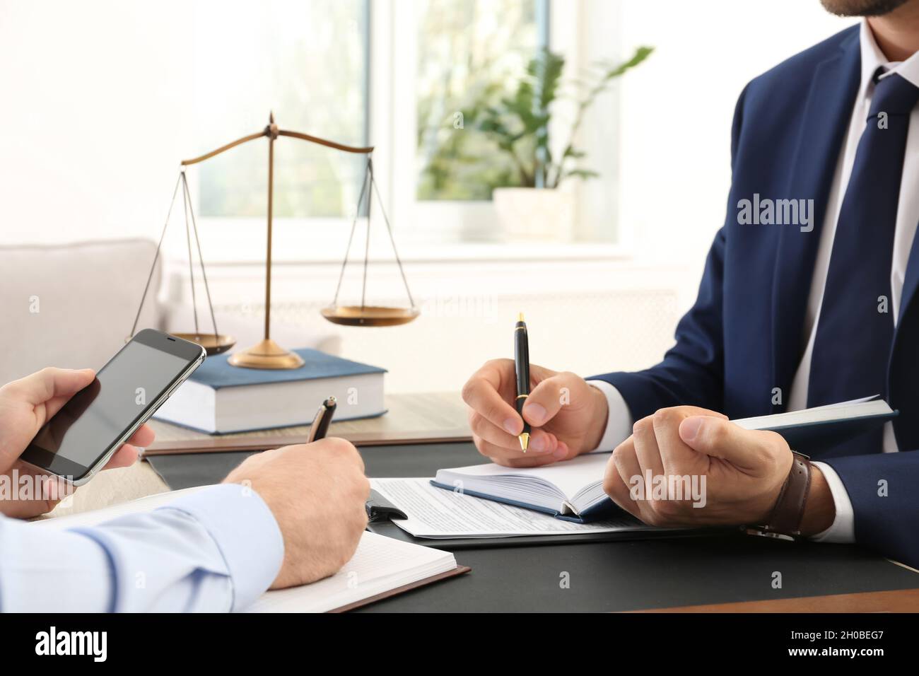 Lawyer working with client at table in office, focus on hands Stock ...