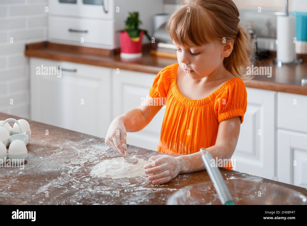 Beautiful little girl cooking in kitchen interior. Little child ...