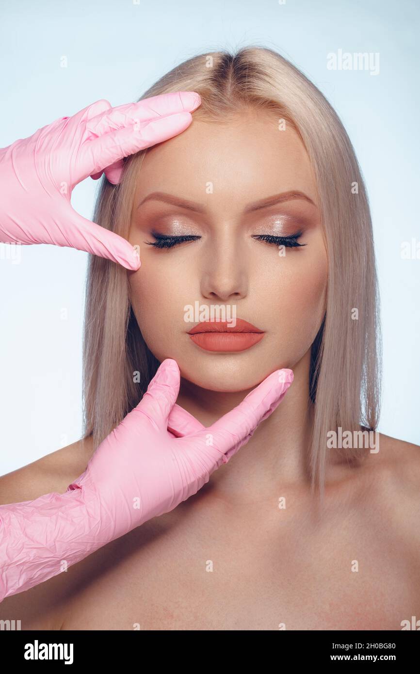 Beautiful woman with perfect smooth skin being checked by doctor ...