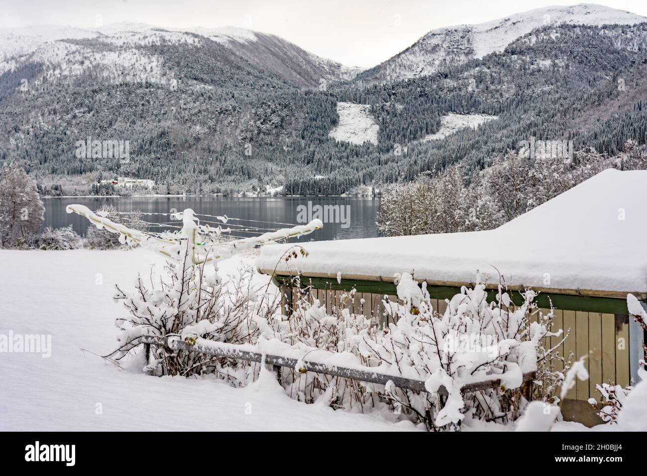 Scenic view of a frozen lake and snow-covered hills in Volda village ...
