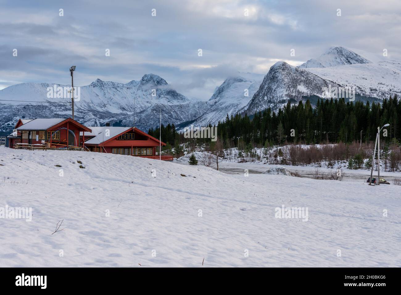 Cottages and snow-covered mountains in the skiing area in Volda village ...