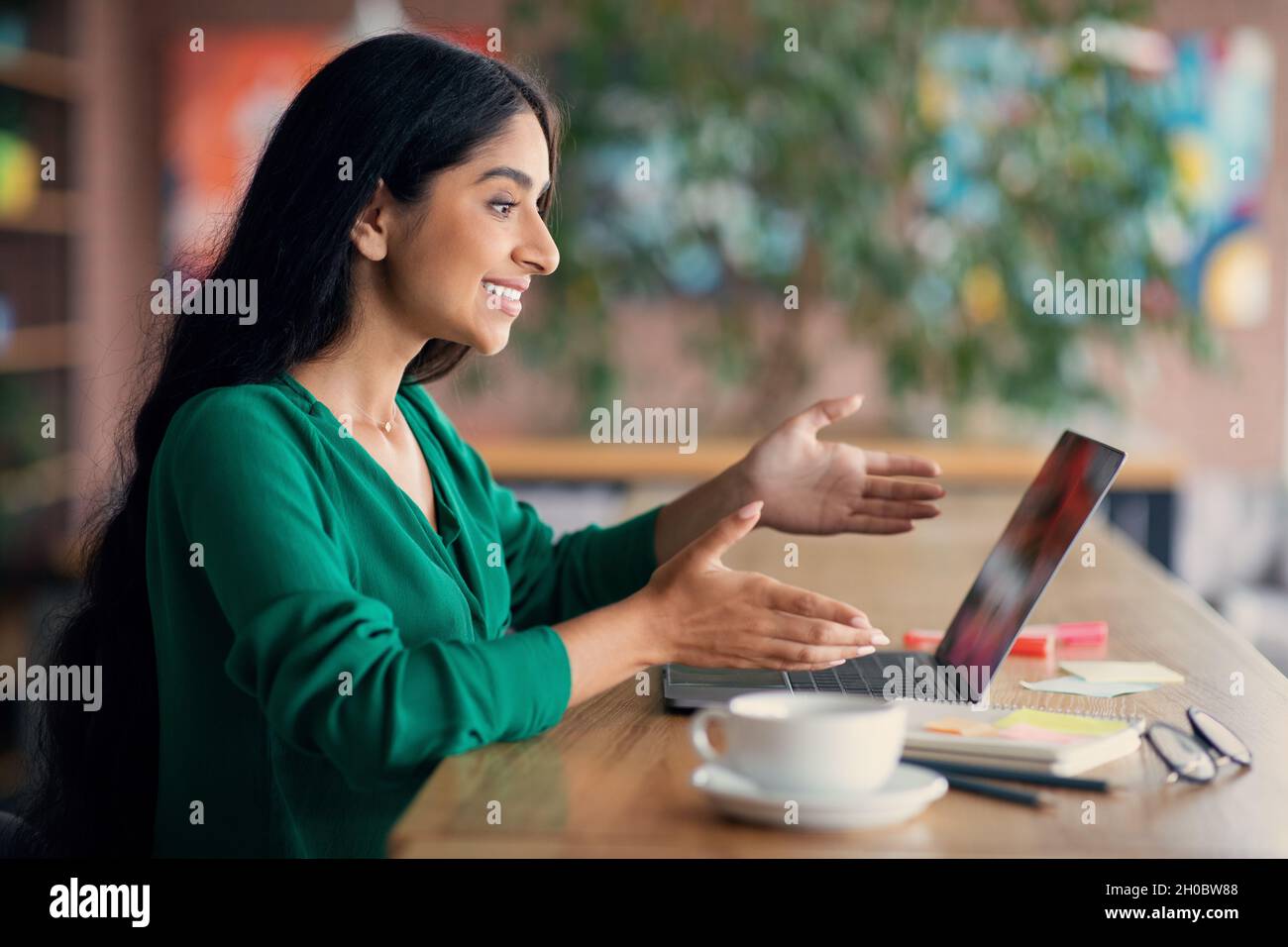 Long-haired indian lady having online job interview, cafe interior ...