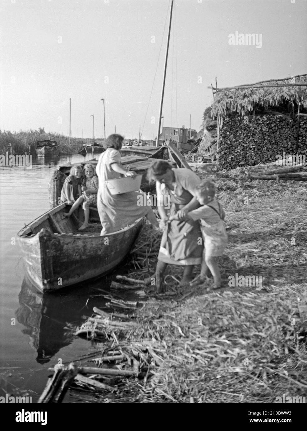 Frauen und Kinder steigen in ein Boot im Dorf Inse im Memeldelta ...