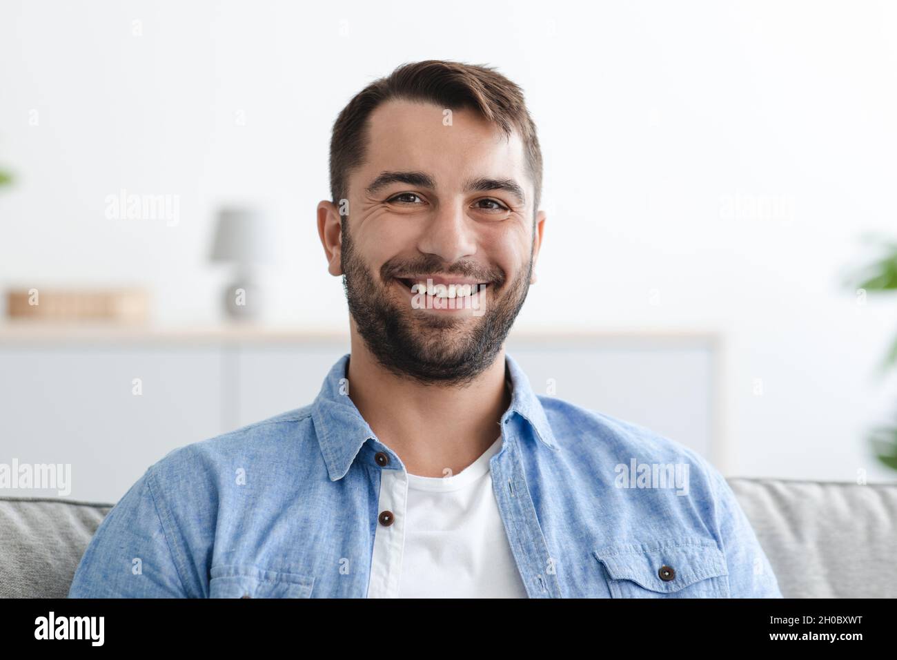 Headshot of cheerful adult european male with beard looking at camera ...