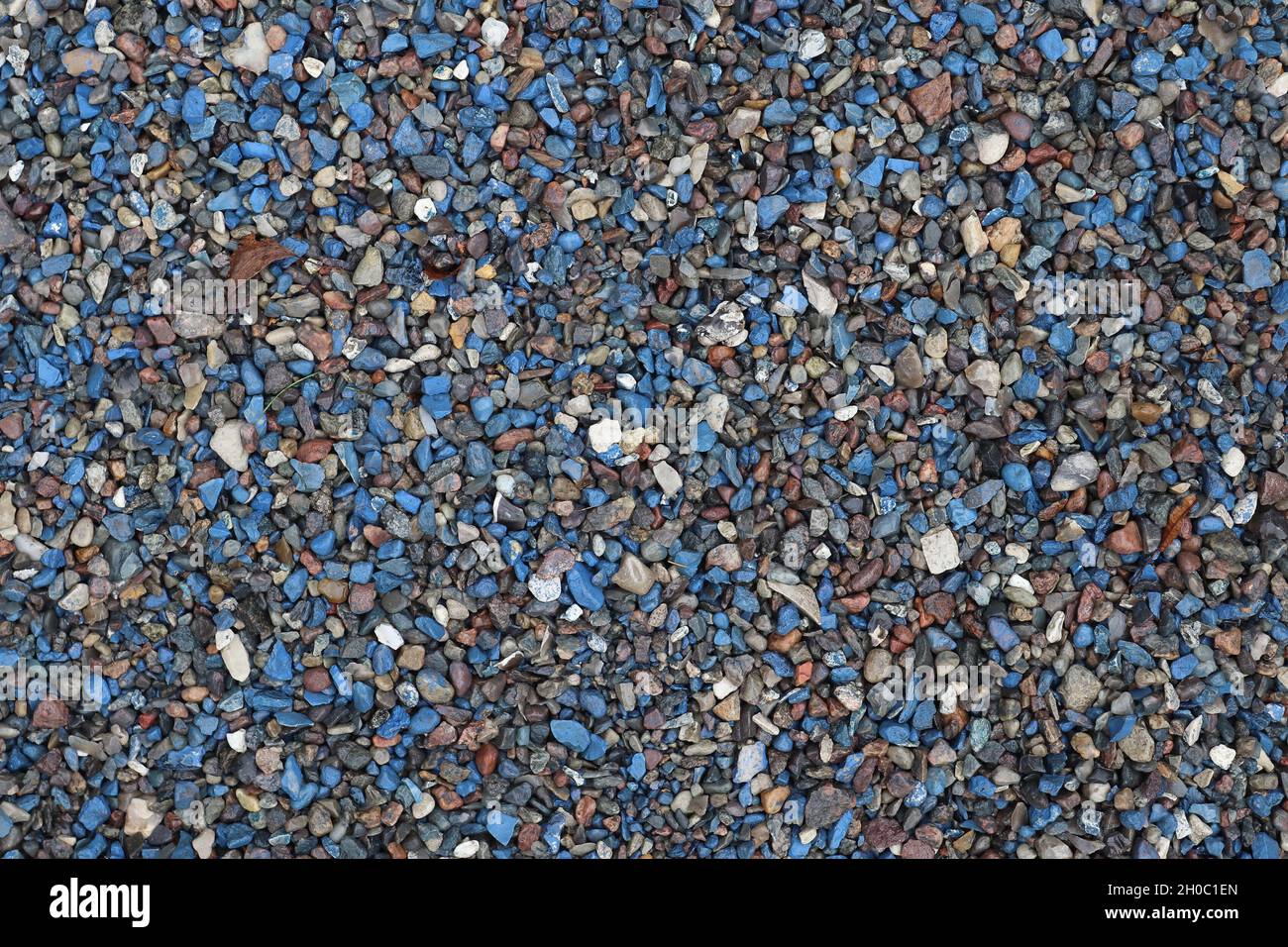 Close up view on blue pebbles and stones on a gravel ground texture in ...