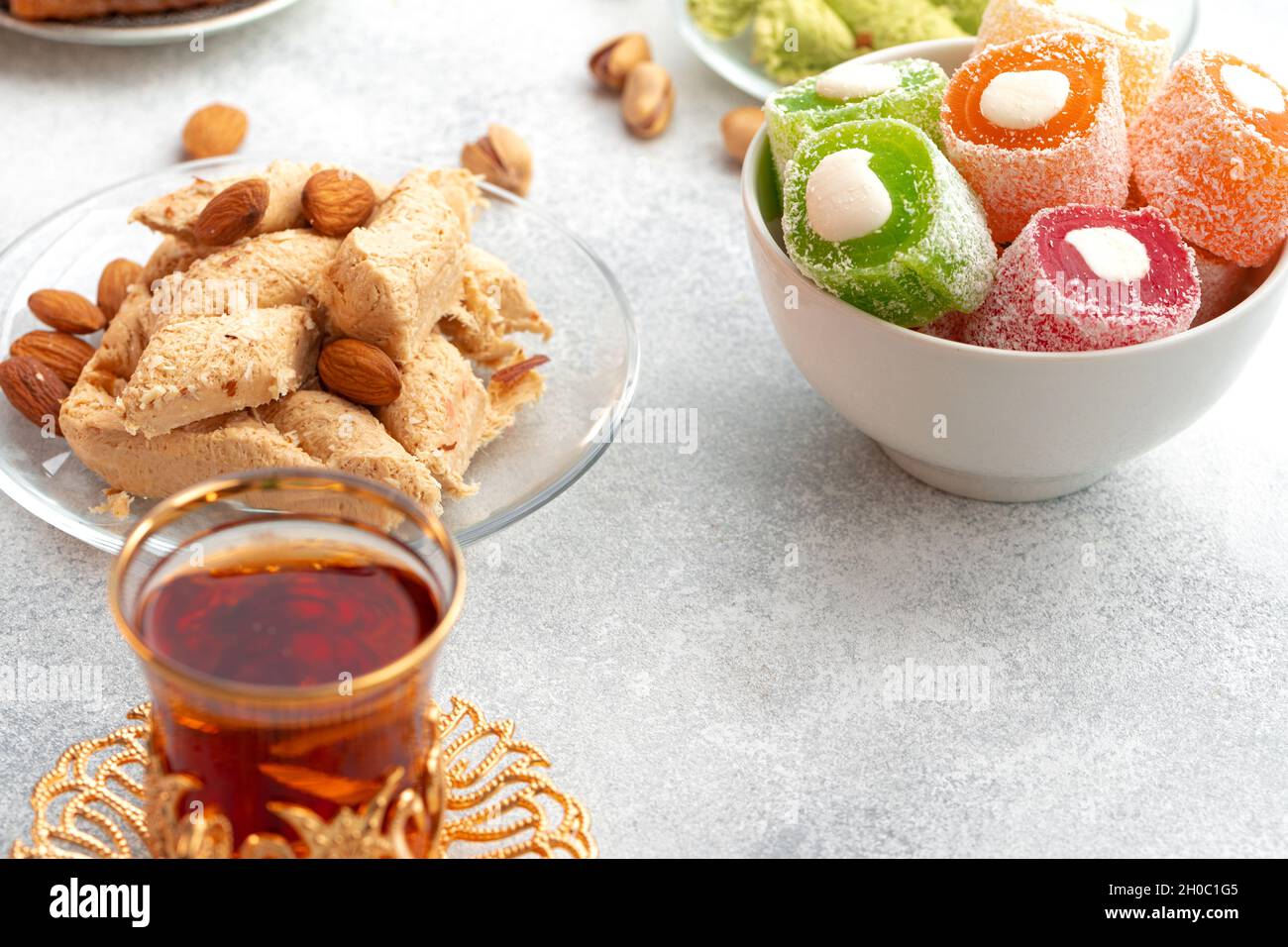 Assortment of Turkish delights with glass of tea on gray background ...